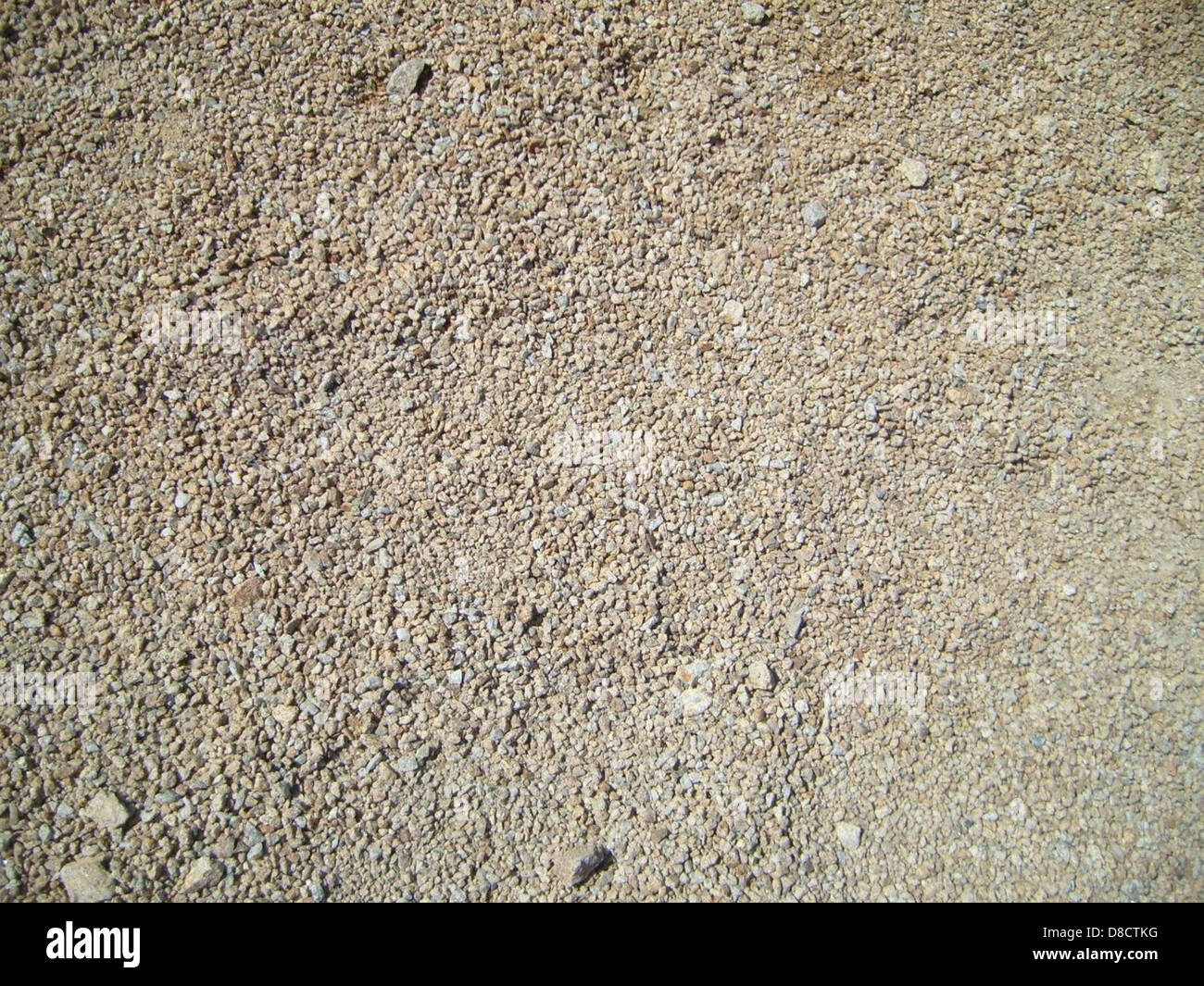 A close-up view of light brown earth, showcasing a natural soil texture ...