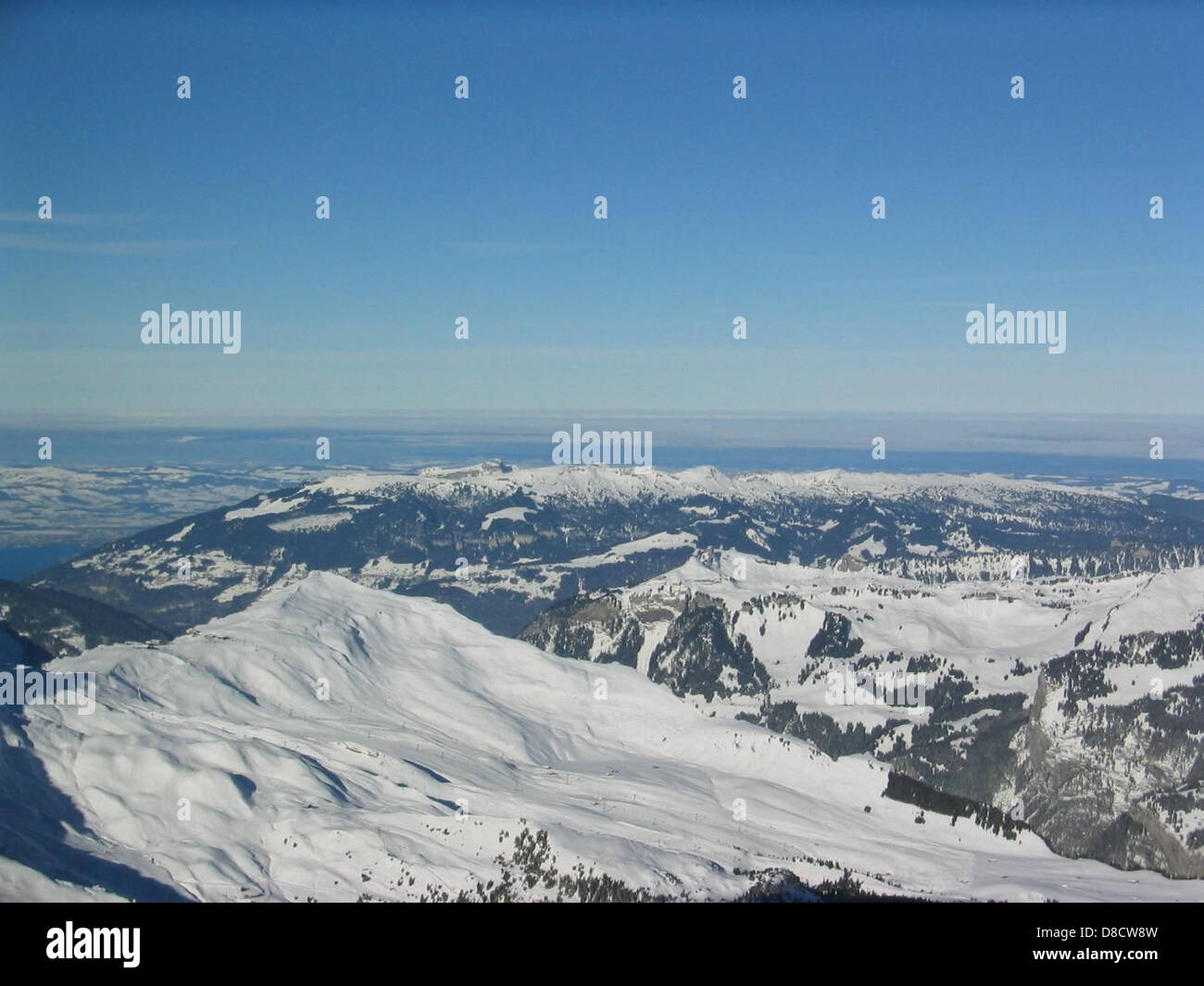 This image captures a vast mountain range with snow-covered peaks ...