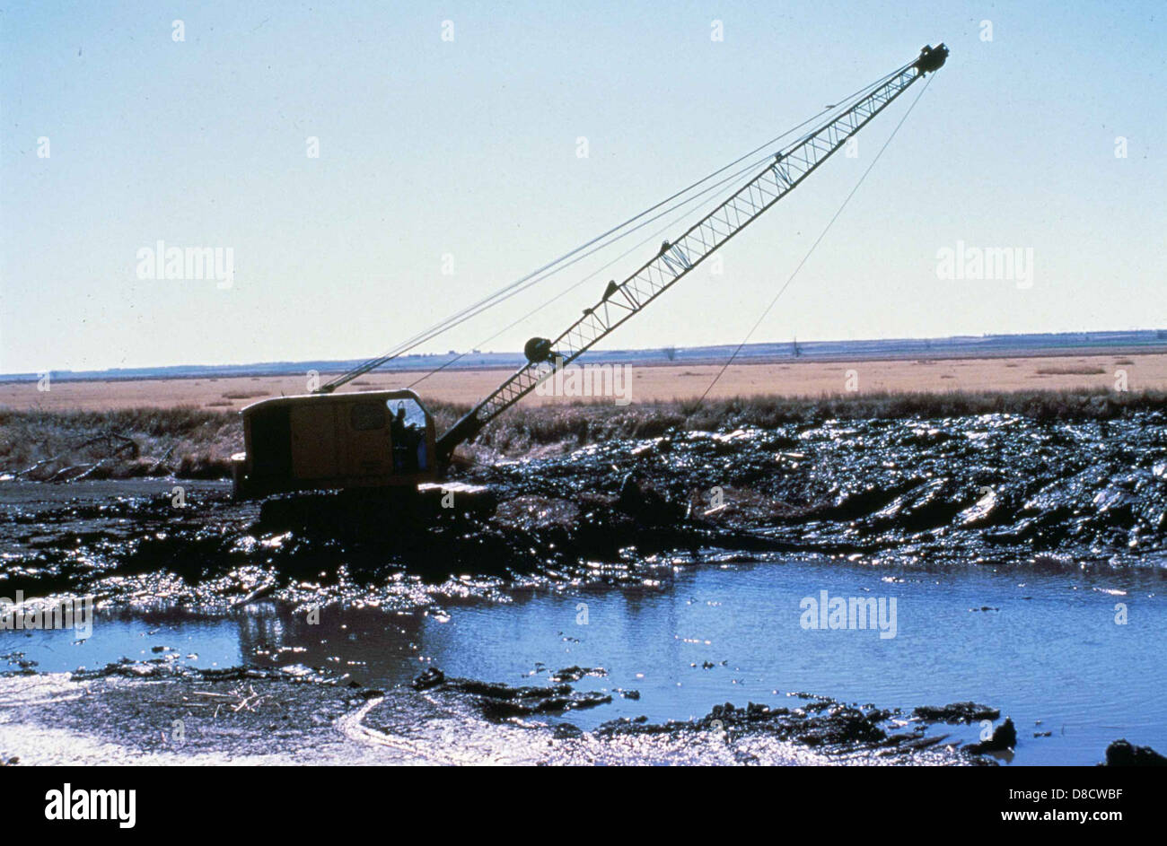 A machine is seen dredging a canal, removing sediment and debris to ...