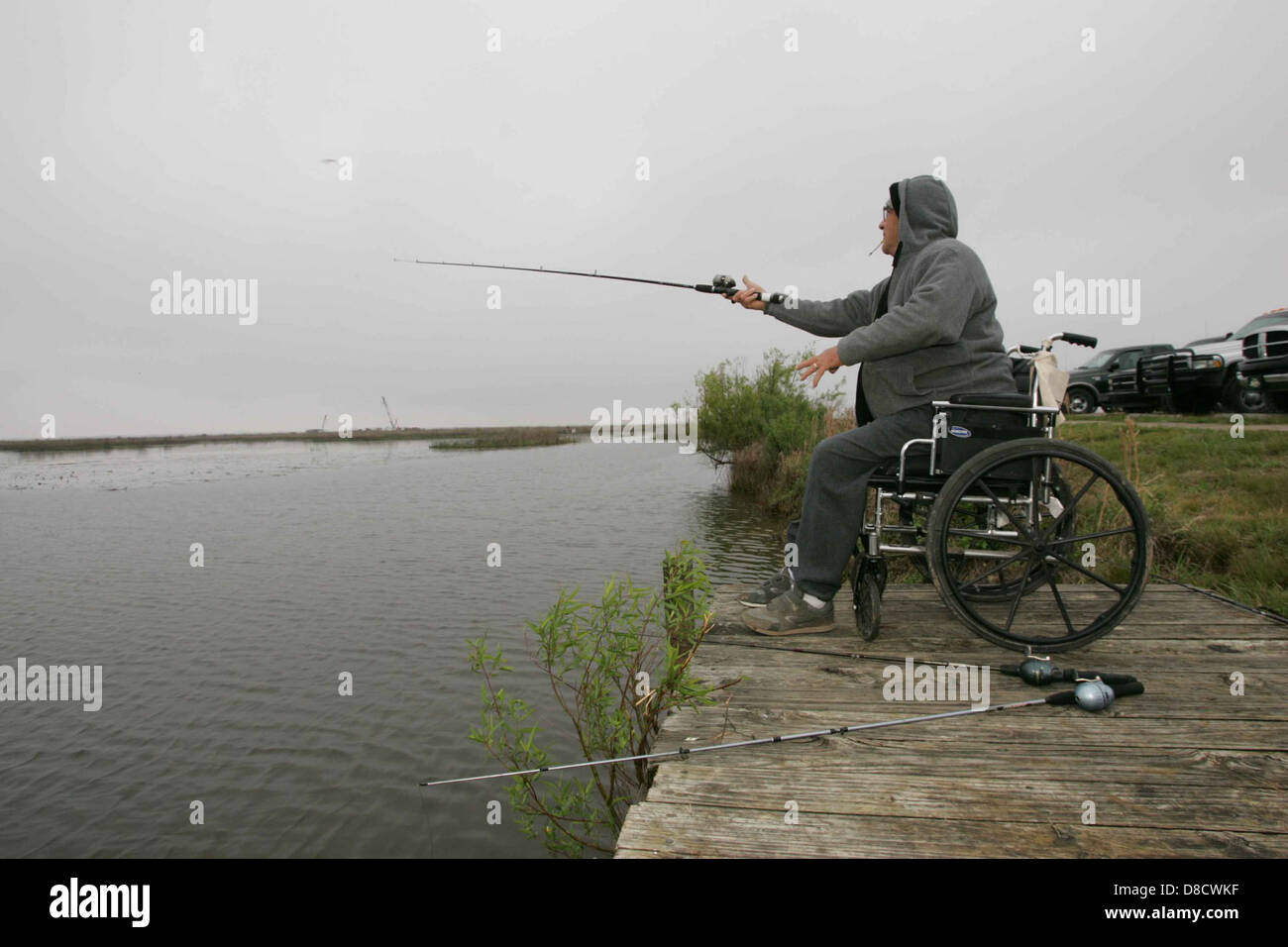 A man sitting in a wheelchair while fishing, highlighting accessibility ...
