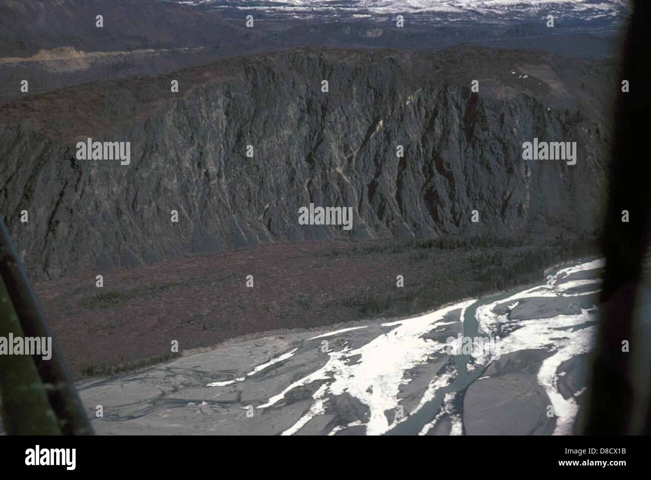 A wide view of the Matanuska River with a high river bluff in the ...