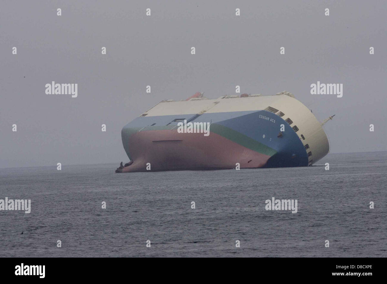 A cargo ship is seen aground, stranded on a rocky shore. This situation ...