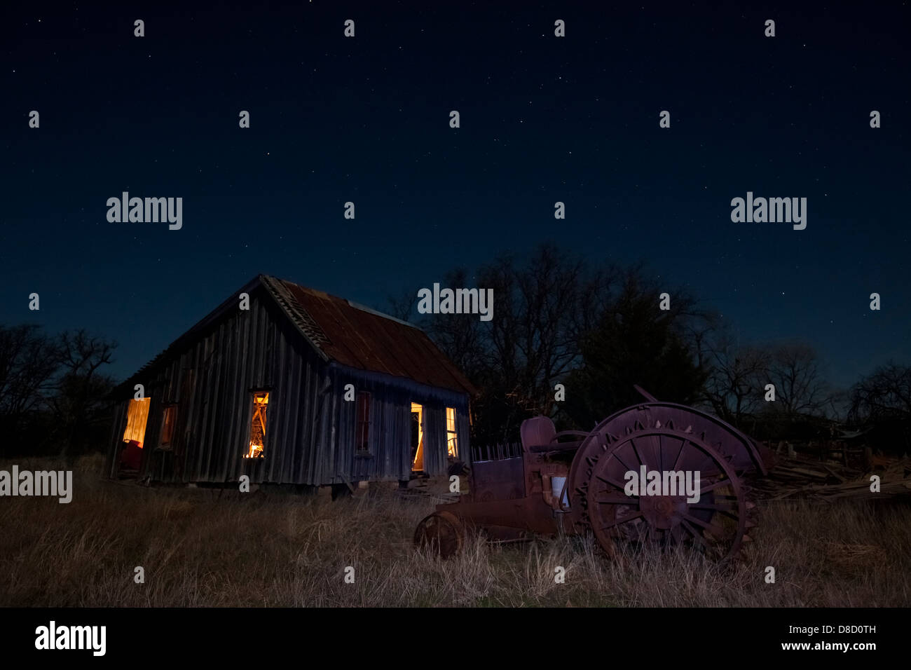 Old abandoned farm house and tractor at night out in West Texas, USA ...