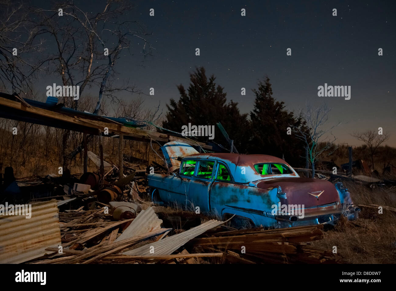 Old abandoned farm and Cadillac car at night in a field in West Texas ...