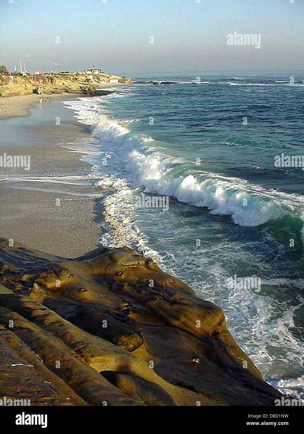 A scenic view of an ocean beach, where the waves crash onto the shore ...