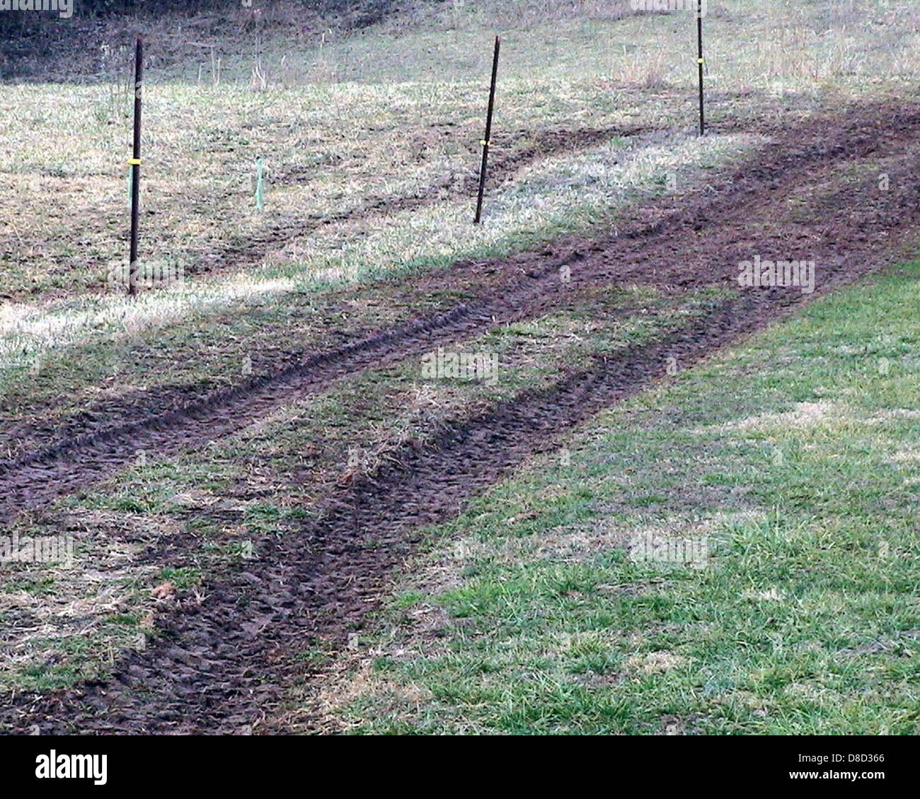 A muddy farm road after a rainstorm, showing uneven terrain and a ...