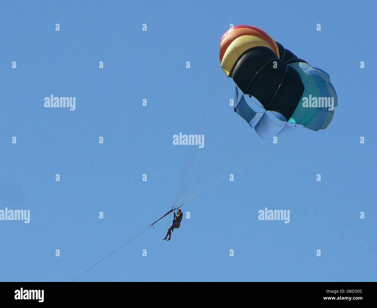 A parachutist in mid-air performing a jump or stunt, captured in the ...