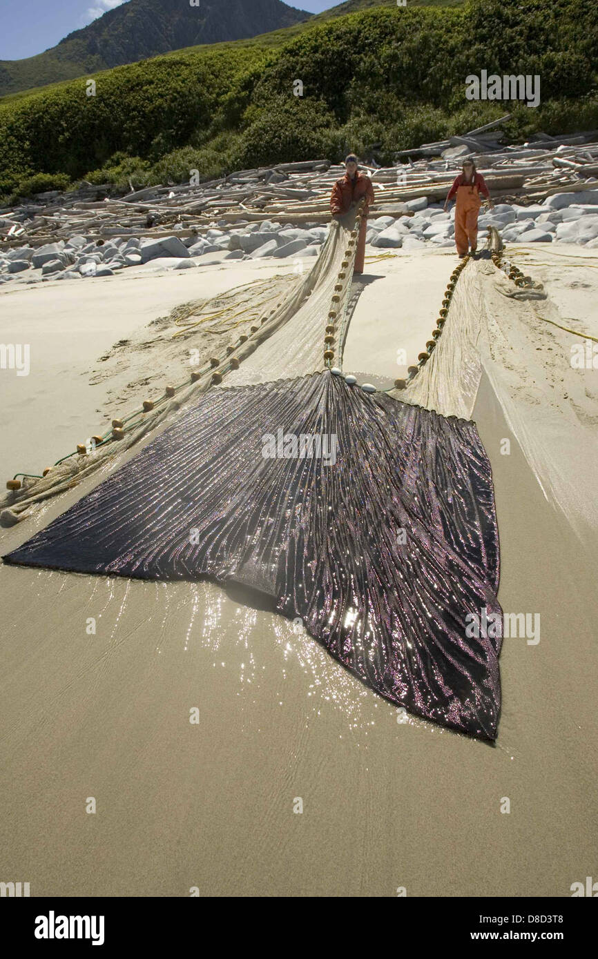 A group of people standing at the beach, preparing to use a fishing net ...