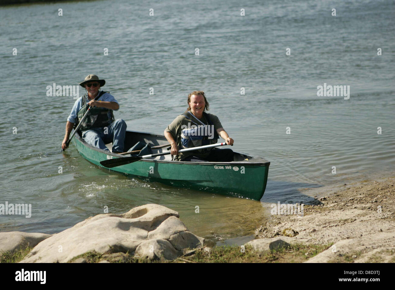 This image shows a group of people canoeing on calm waters, enjoying a ...