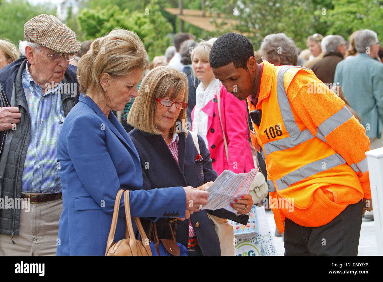 A steward helps visitors to the RHS Chelsea Flower show make sense of ...