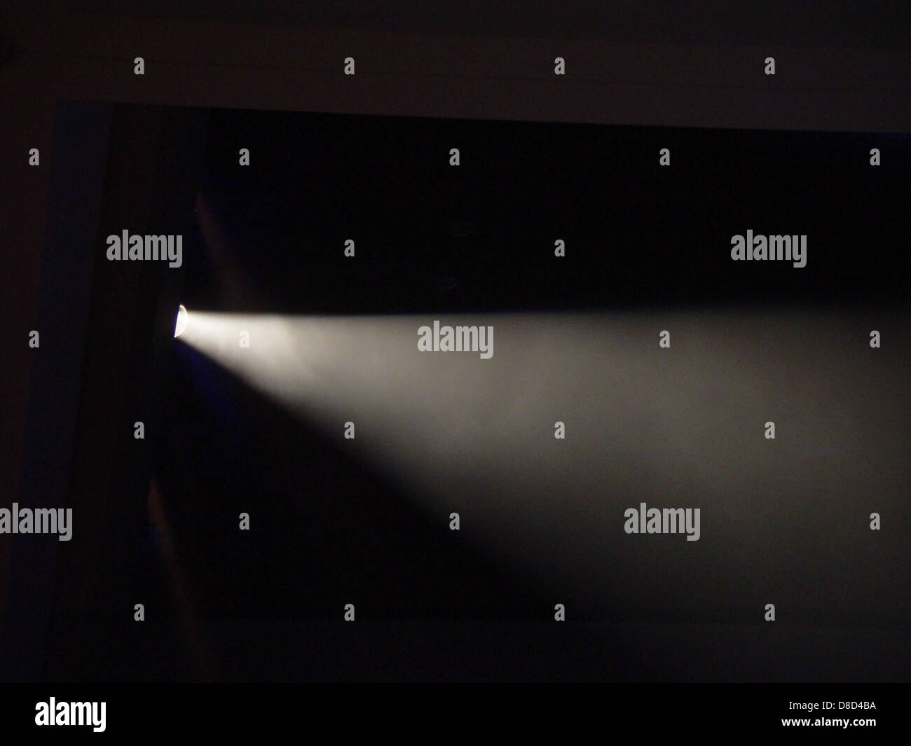 A close-up of a pin spot spotlight casting a sharp beam of light ...