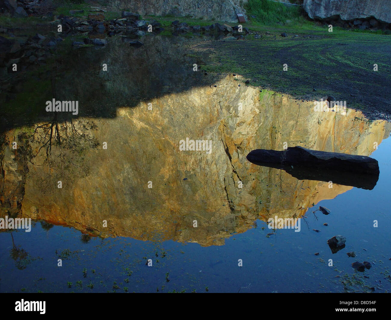 This image shows a quarry surrounded by rocky terrain, with a pool of ...
