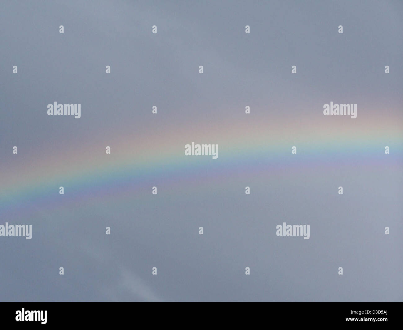 A vibrant rainbow arching across the sky, with vivid colors stretching ...
