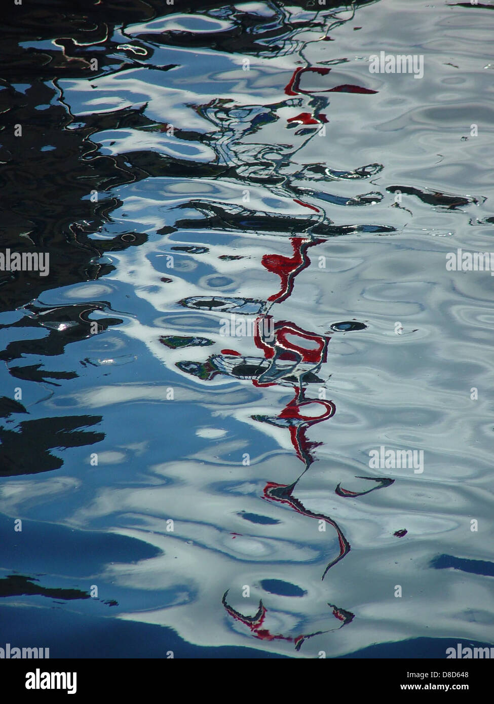 This photo shows a reflection of colorful kites in the water ...