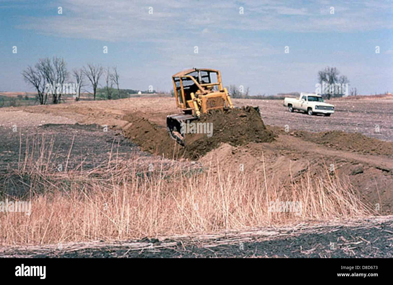 A restored wetland area with a heavy vehicle working on land management ...
