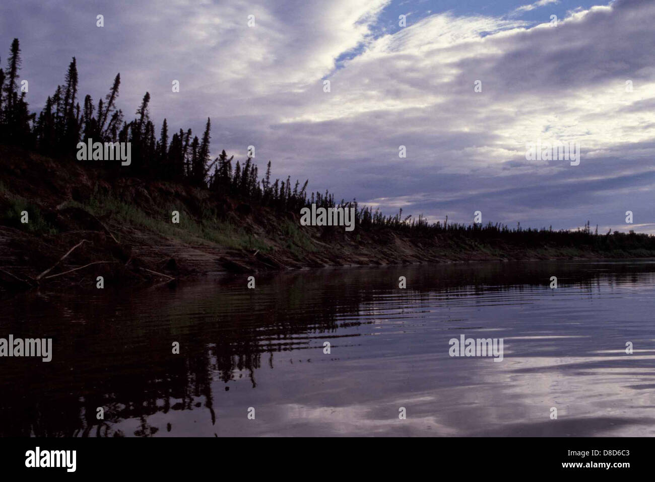 This photo captures a riverbank landscape with flowing water ...