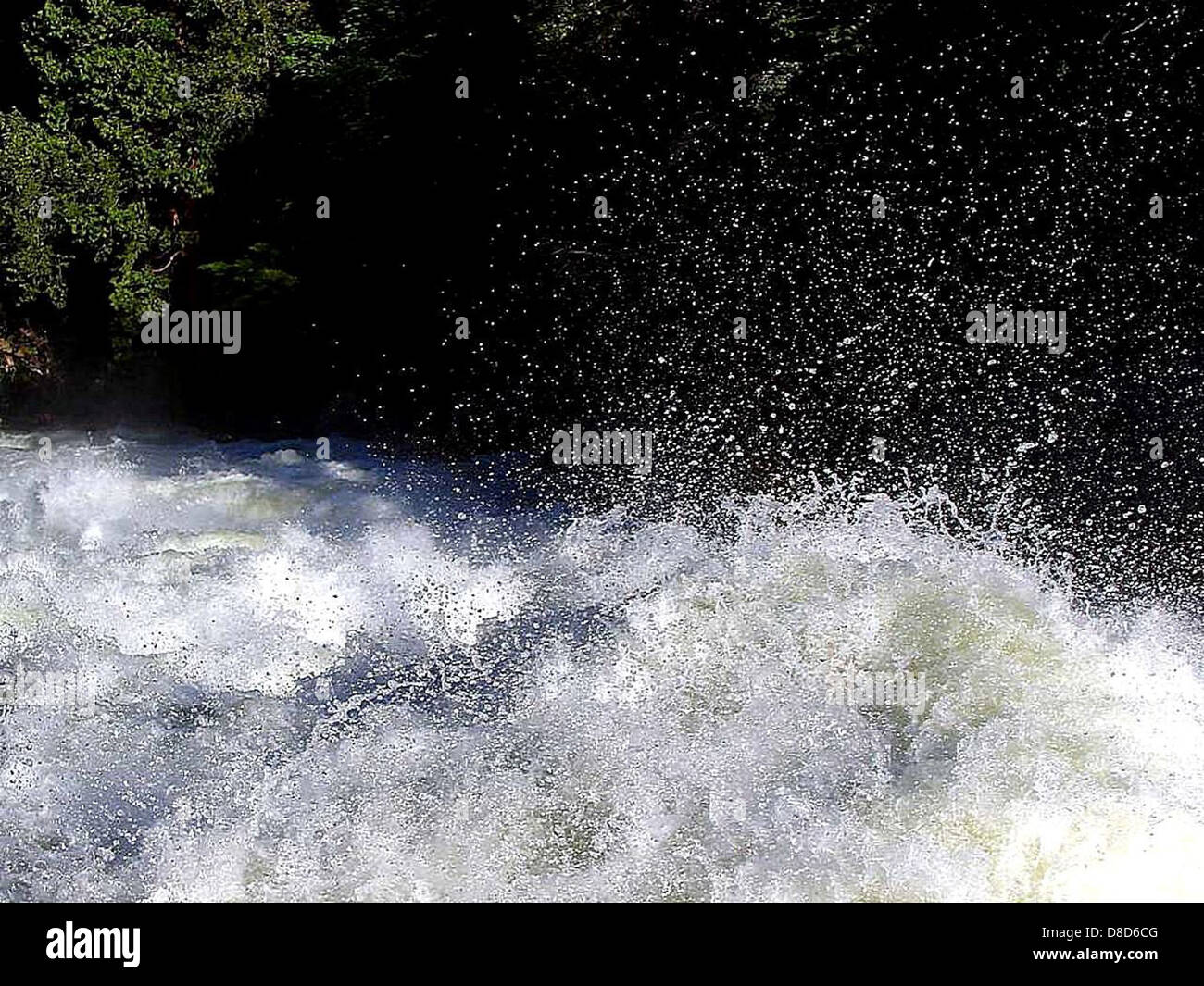 A river with foam and splashing rapids as the water moves swiftly over ...