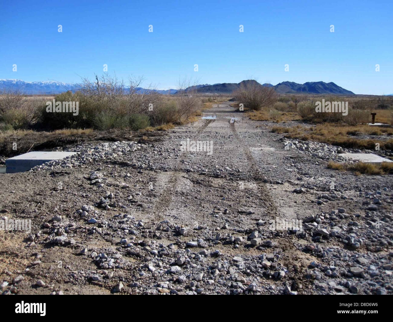 A road severely damaged by debris and erosion caused by flooding. The ...