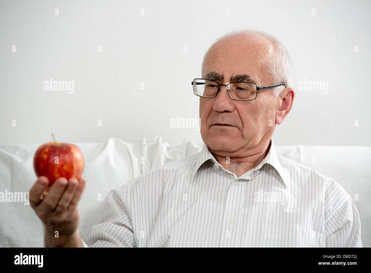 elderly man holding an apple in his hand Stock Photo - Alamy