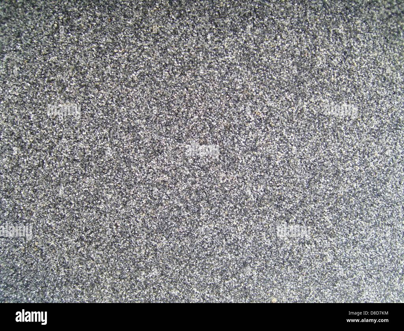 A close-up image of sand and small pebbles showcases the natural ...