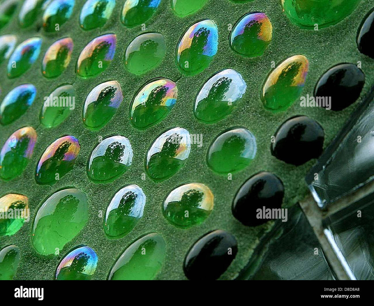 A sculpture crafted from glass reflects light and surroundings ...