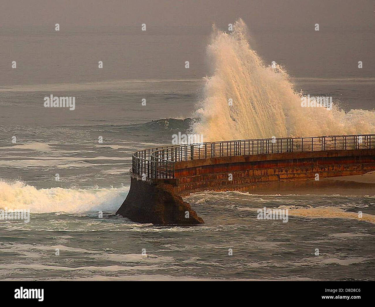 The image captures the dynamic movement of sea waves crashing onto one ...