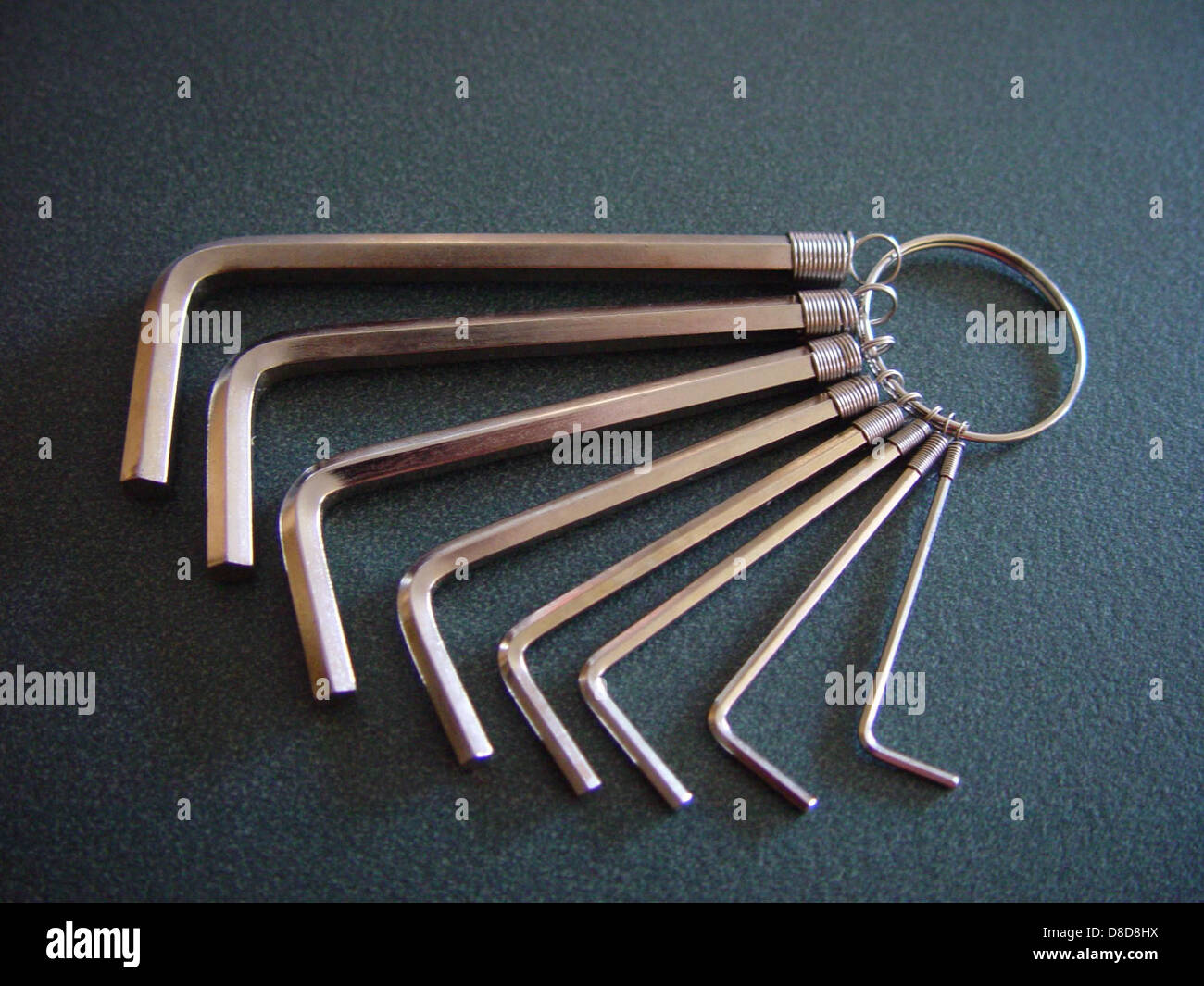 A set of eight hex allen keys, mounted on a ring, sits on a table ...