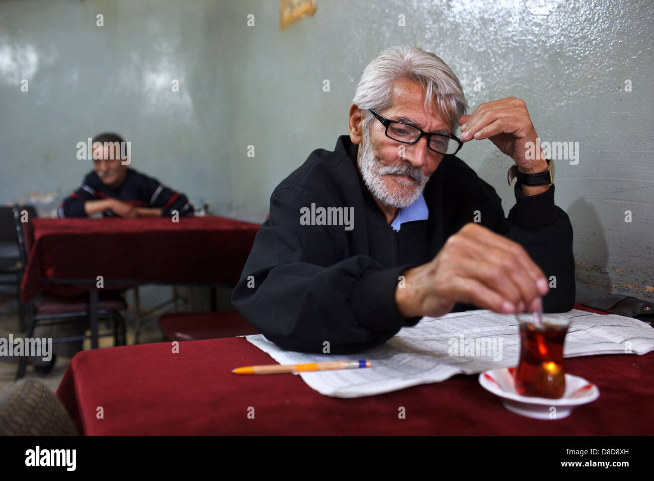 An old Turkish man drinking tea and reading newspaper in a cafe (tea ...