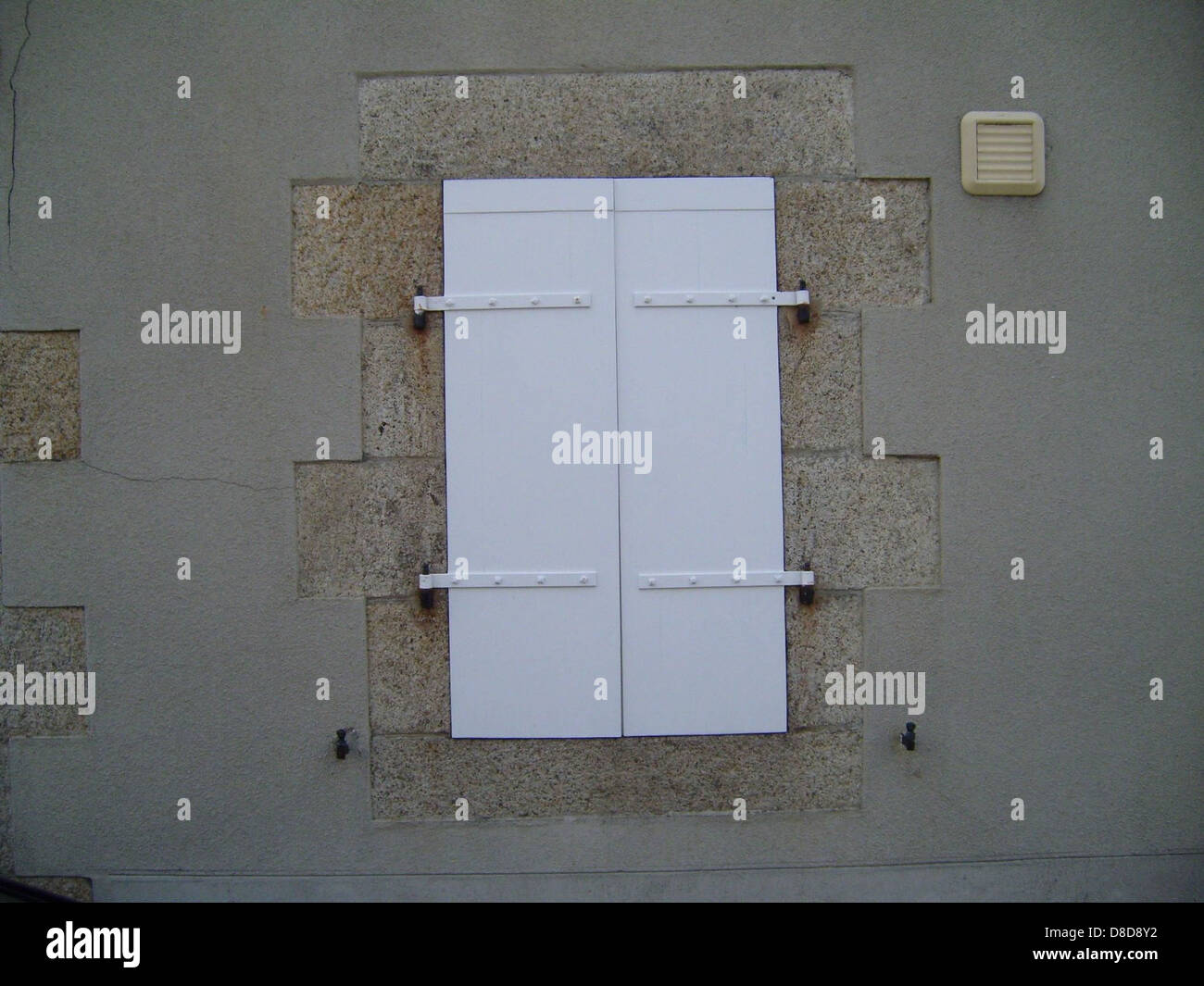 This image features a set of shutters placed on a window, commonly used ...