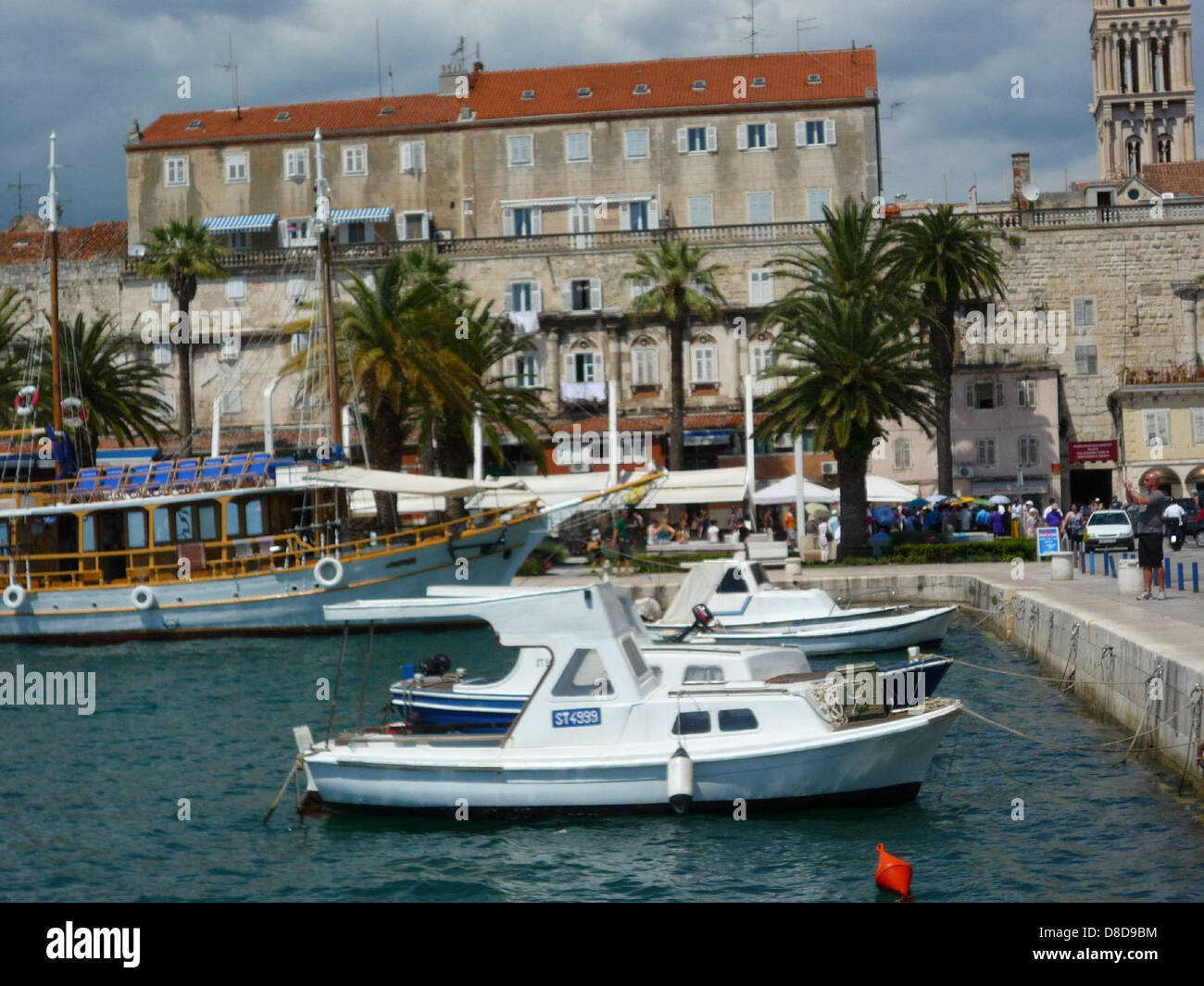 This image shows several small boats docked at a harbor. The boats are ...