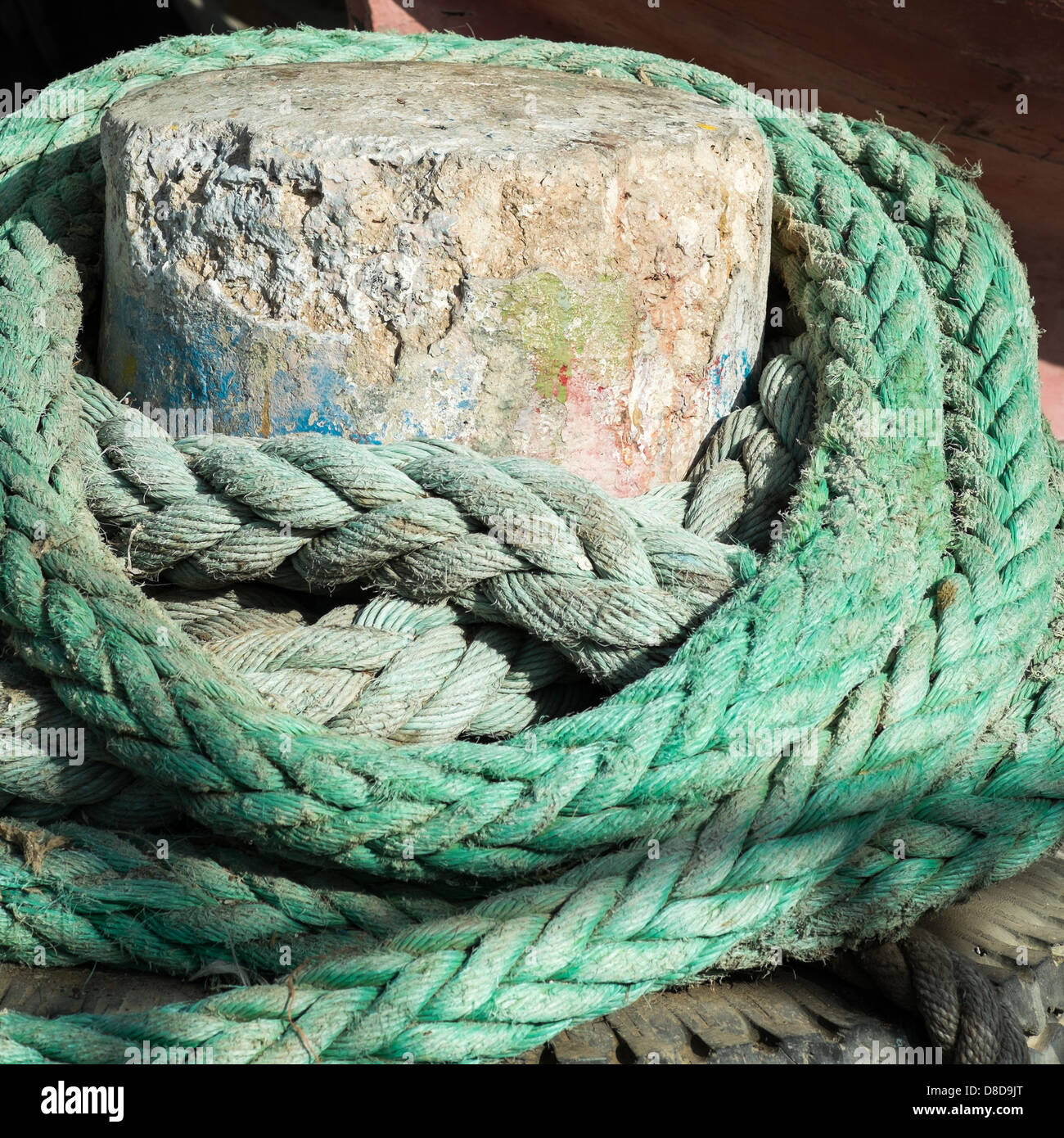 Weathered rope around a concrete post in sunlight Stock Photo - Alamy