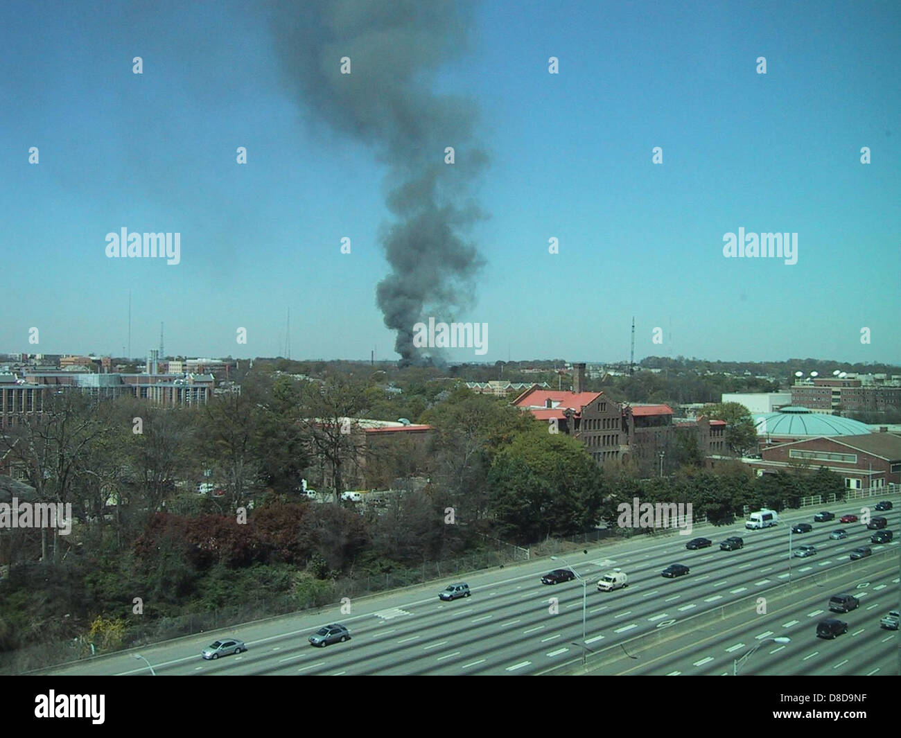 This image shows a stream of smoke rising from a house fire, with the ...