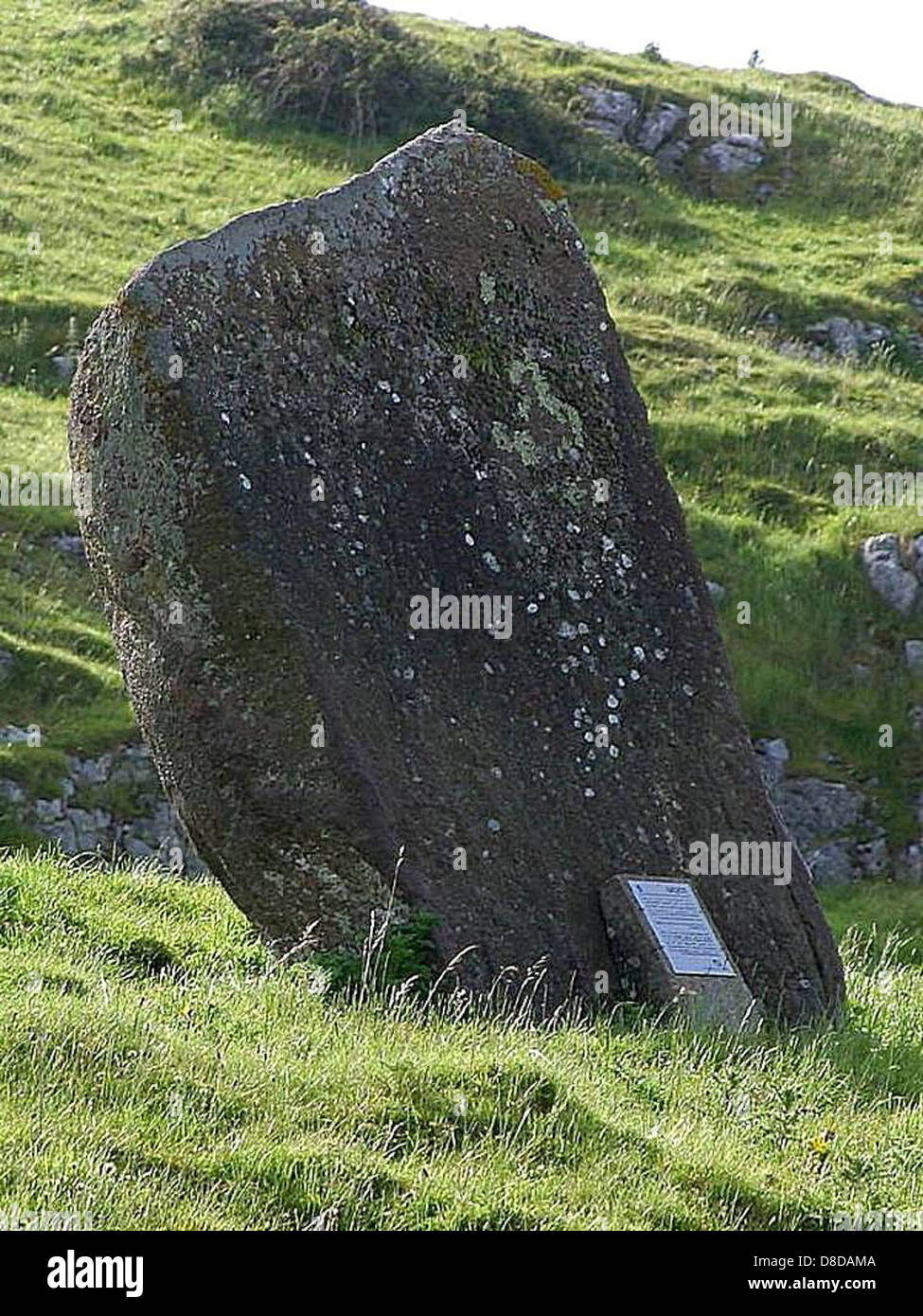 The image features a large, upright standing stone, possibly an ancient ...