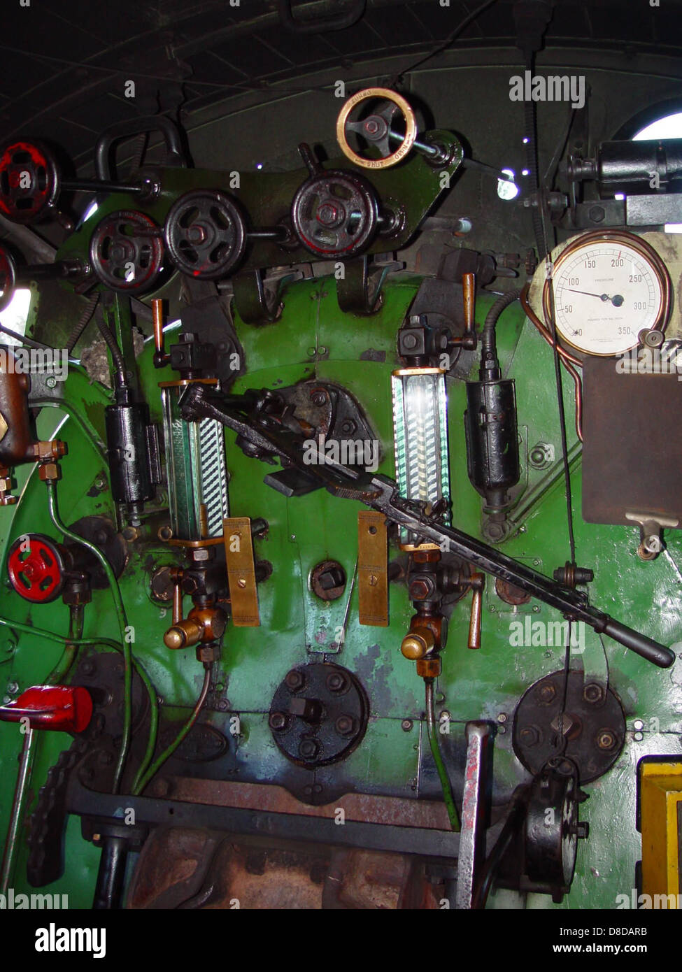 The controls and dials of a steam locomotive are visible in a close-up ...