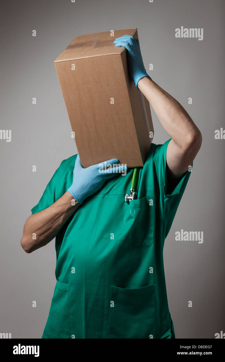 Perplexed doctor with cardboard box head in green uniform Stock Photo ...