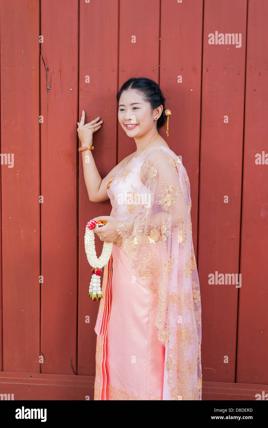 Asian Thai woman/bride in Thai wedding suit is holding flowered garland ...