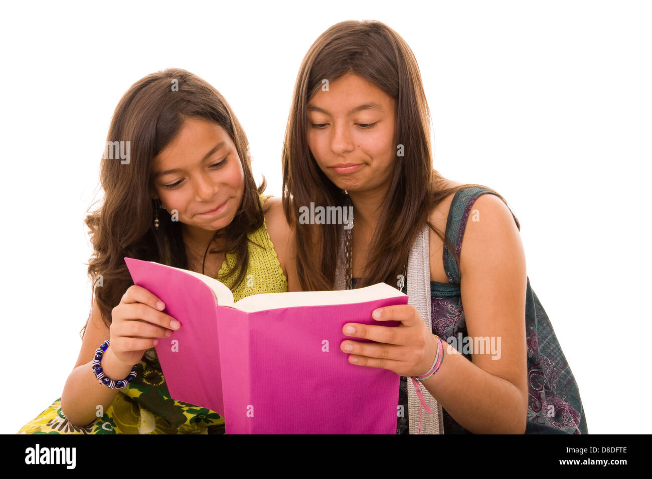 Two young girls reading a school book Stock Photo - Alamy