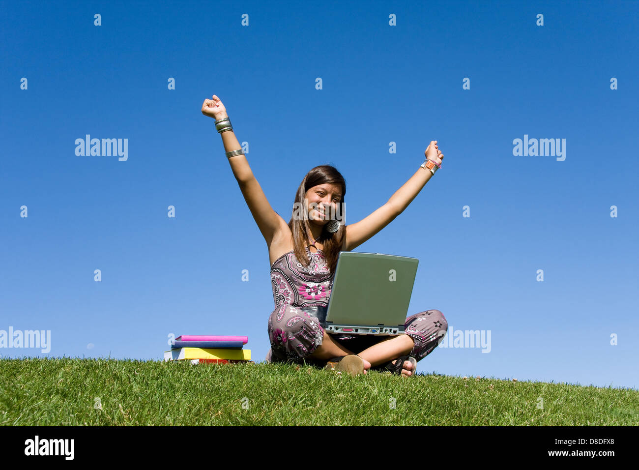 Happy young girl reading something on her laptop Stock Photo - Alamy