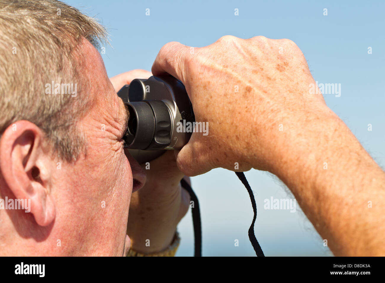 A man looking through binoculars Stock Photo - Alamy