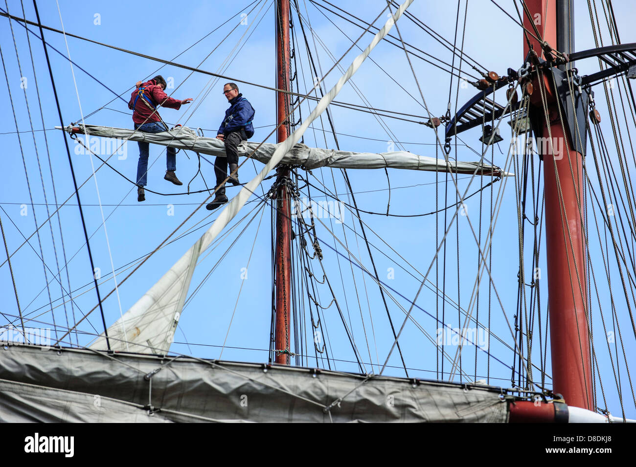 Two sailors sitting on yard of sailing vessel Stock Photo - Alamy