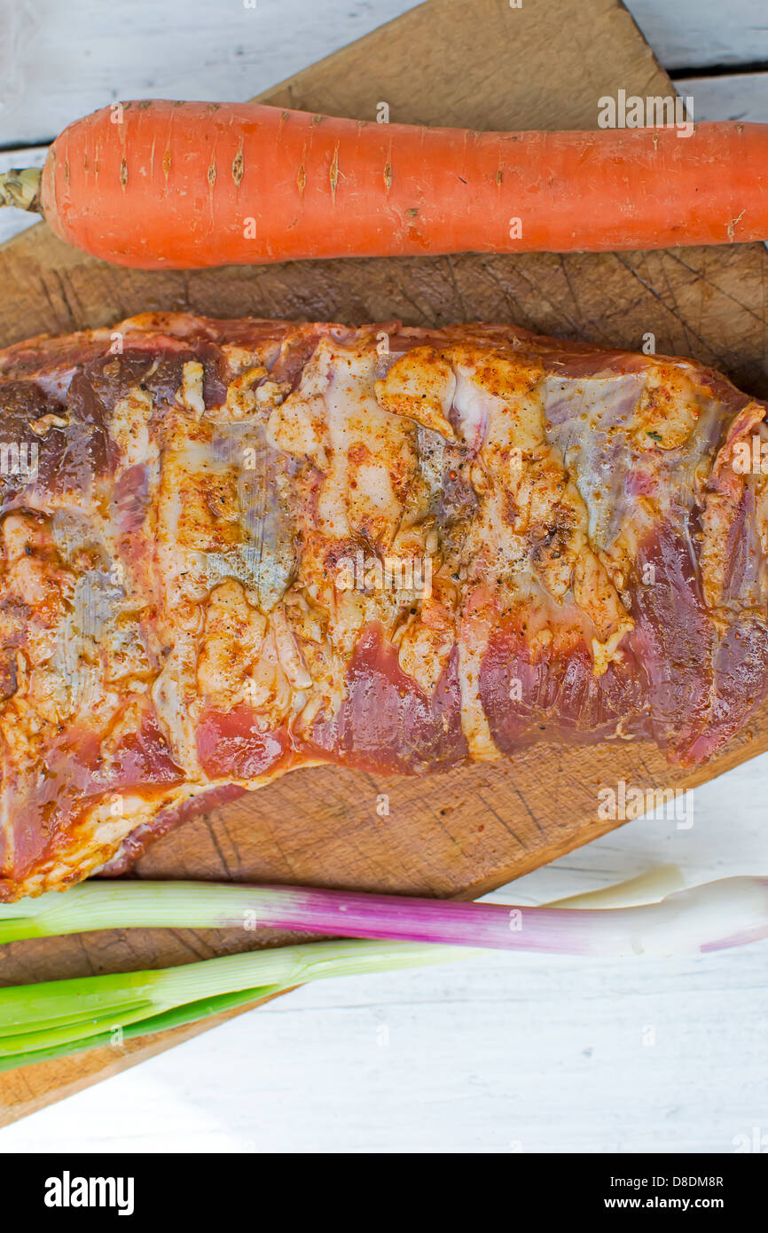 Raw pork ribs seasoned for baking on a wooden board Stock Photo - Alamy