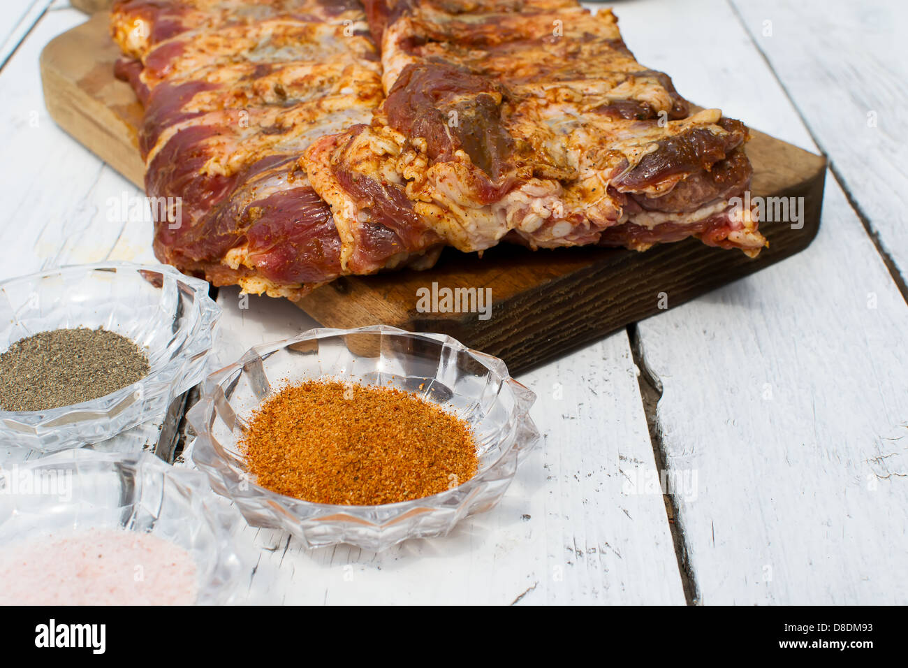 Raw pork ribs seasoned for baking on a wooden board Stock Photo - Alamy