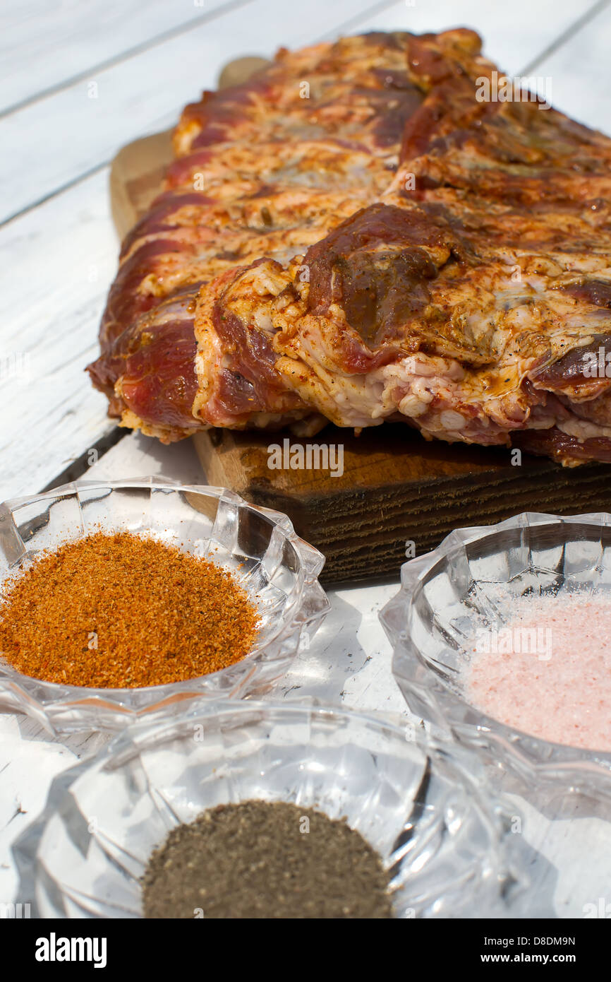 Raw pork ribs seasoned for baking on a wooden board Stock Photo - Alamy