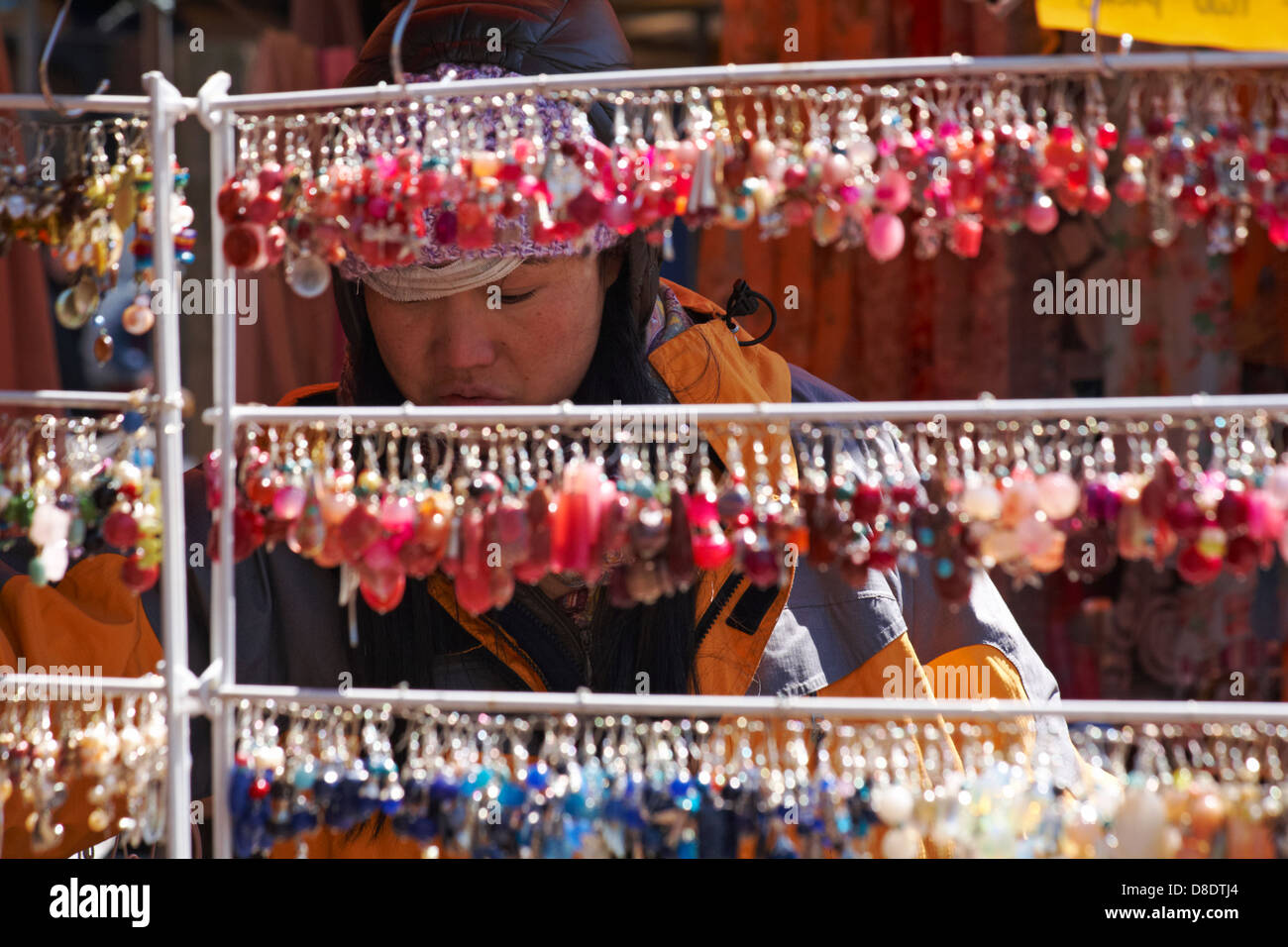 Market stall holder through rows of earrings at Oxford, Oxfordshire UK ...