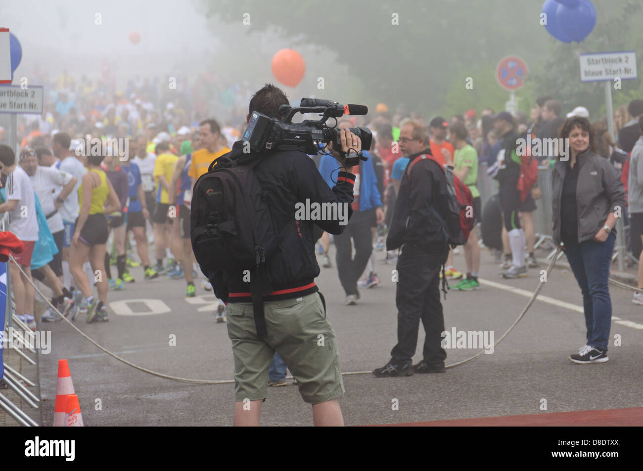 TV cameraman reports from a sport event, marathon run, at a foggy ...