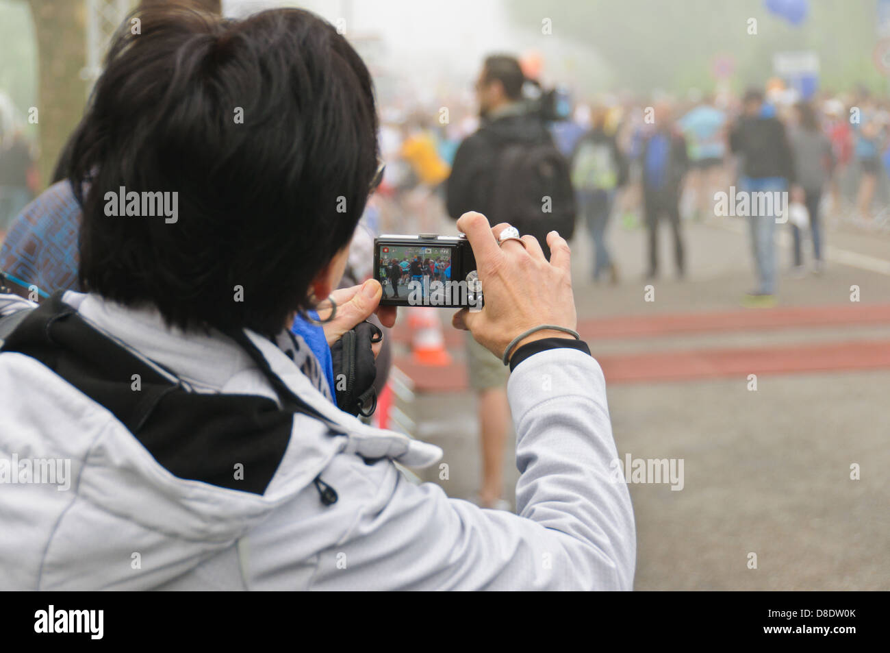 Man with point and shoot digital camera takes pictures of marathon ...