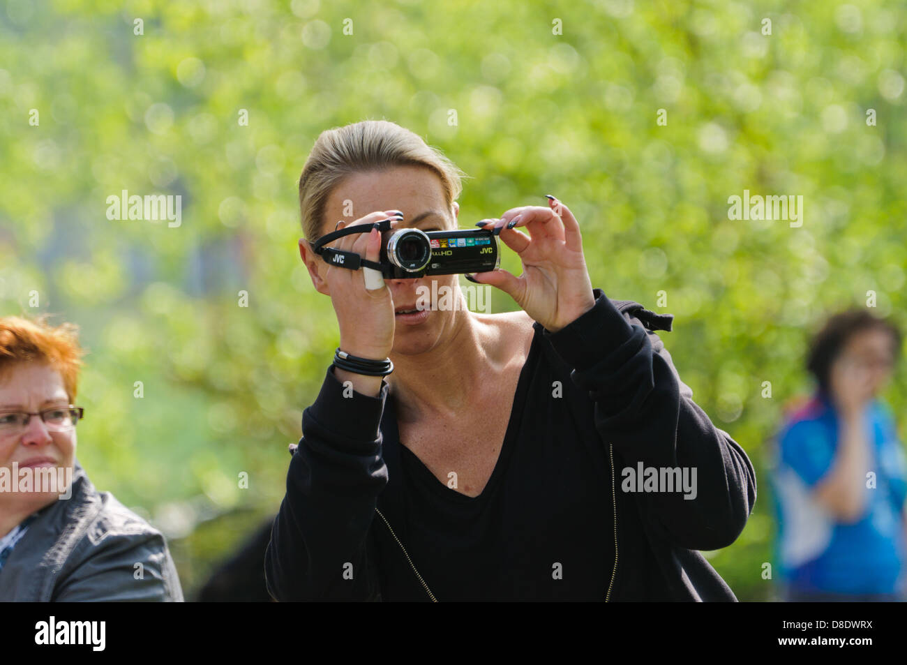 Blond woman videotaping with a JVC camcorder Stock Photo - Alamy