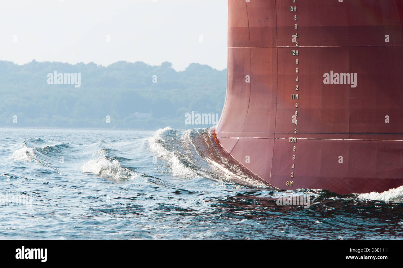 The bow of a large cargo ship pushes through the water in Narragansett ...