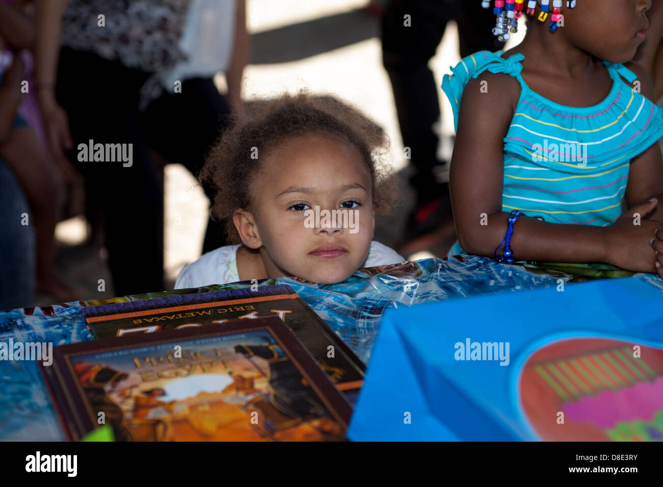 Little girl resting her chin on a table at a birthday party, Finley ...