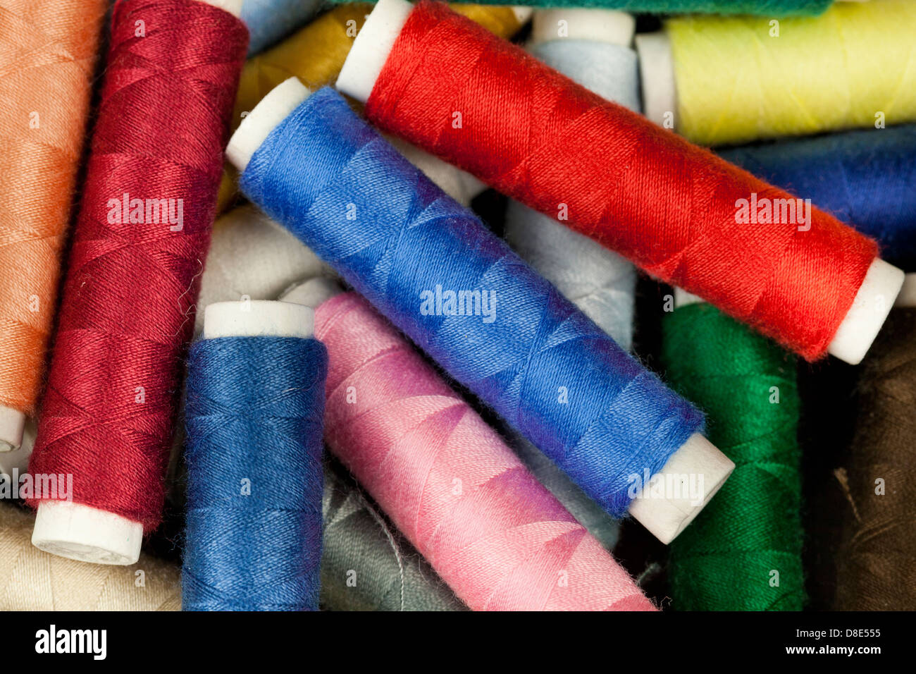 Multicolored sewing threads background Stock Photo - Alamy